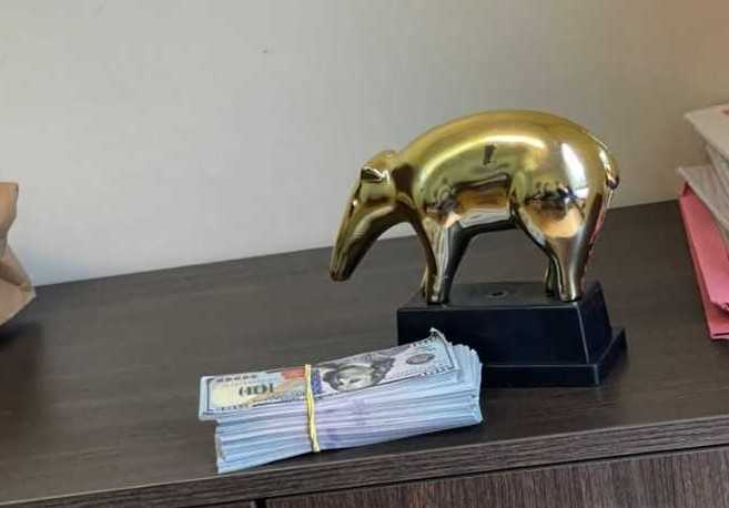 Il consigliere Mariani consegna un tapiro d'oro e una mazzetta di soldi ...